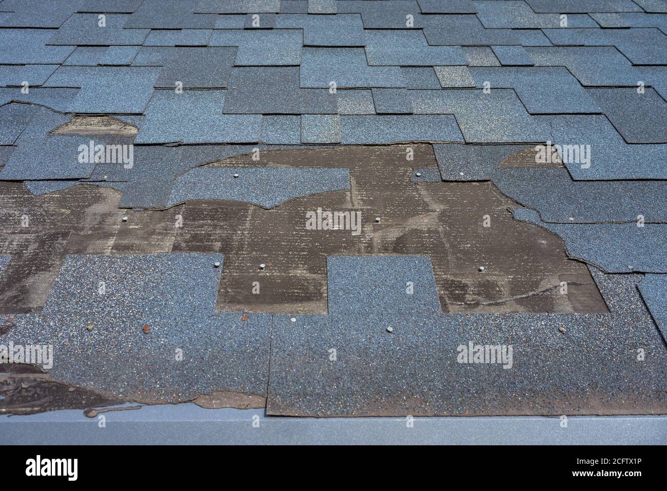 Close up view of bitumen shingles roof damage that needs repair Stock ...