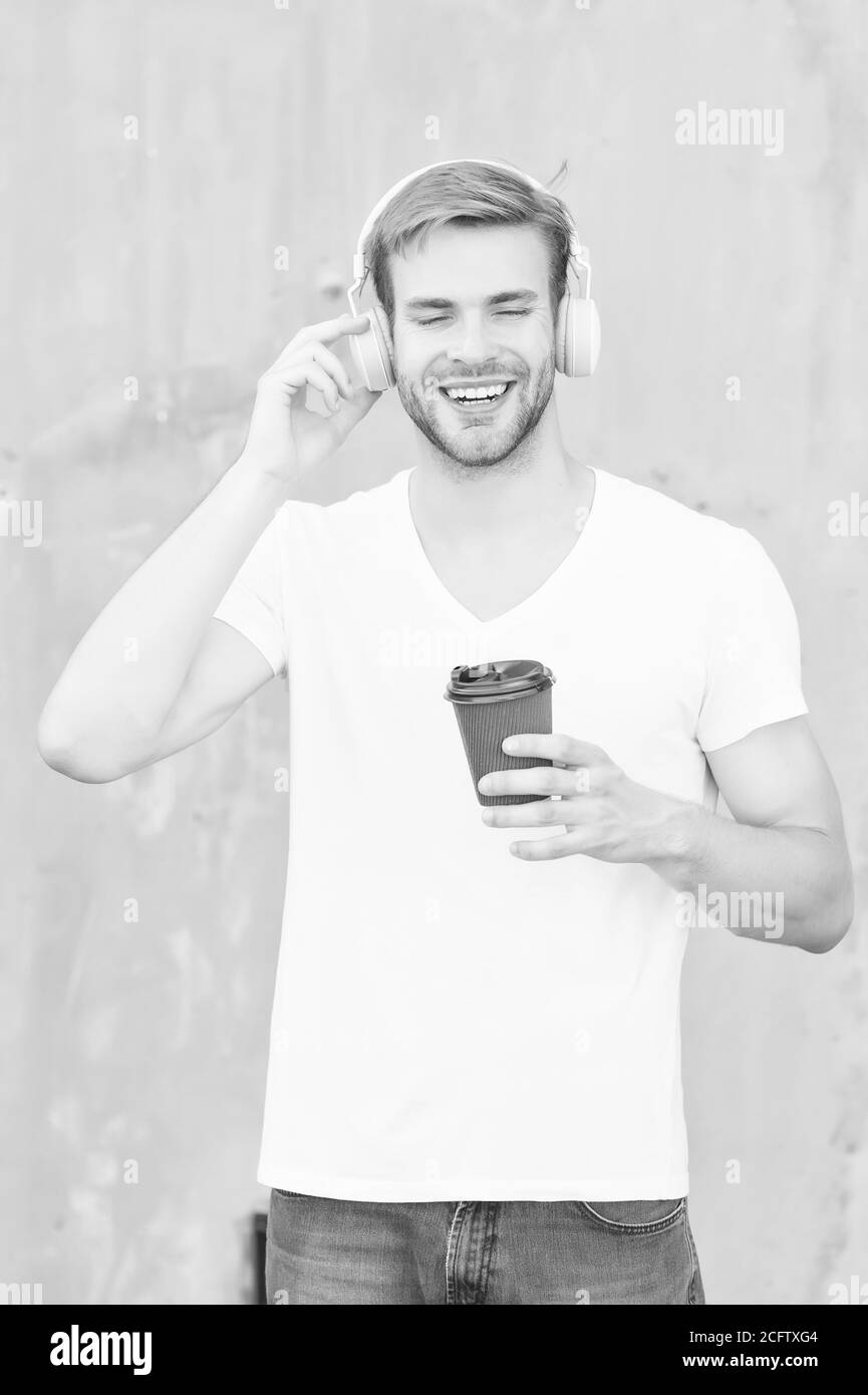 His morning is dedicated to music. Happy guy listen to music drinking ...