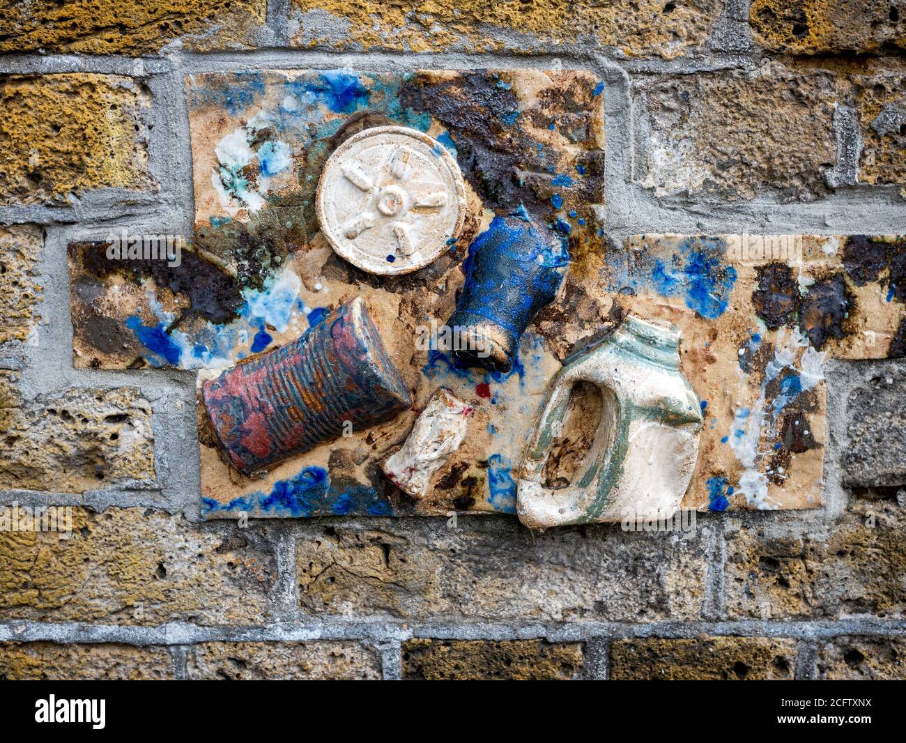 Sculpture of waste packaging embedded in a brick wall, Greenwich Stock ...