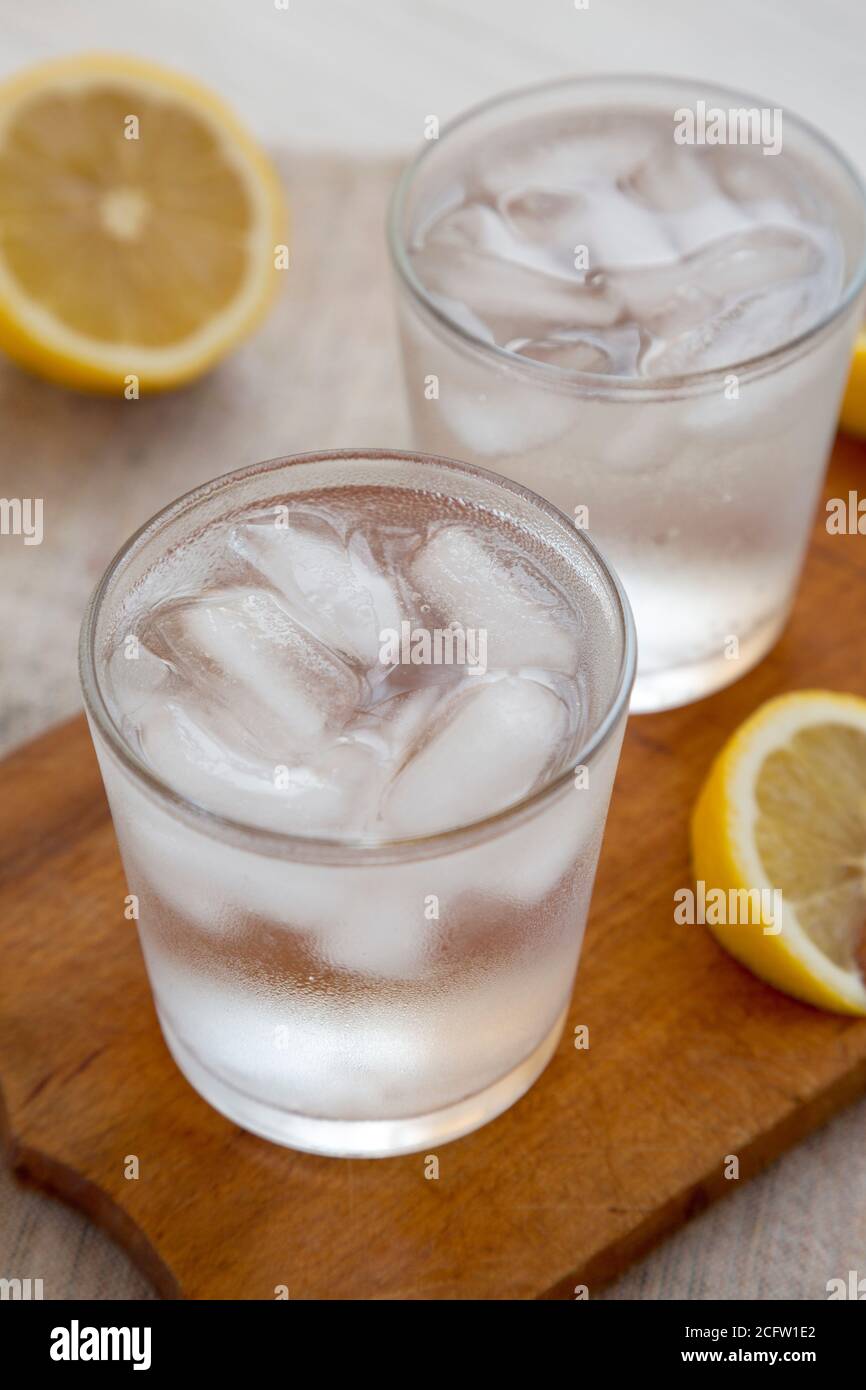 Fresh Lemon Sparkling Water with Ice on a rustic wooden board, side view Stock Photo - Alamy