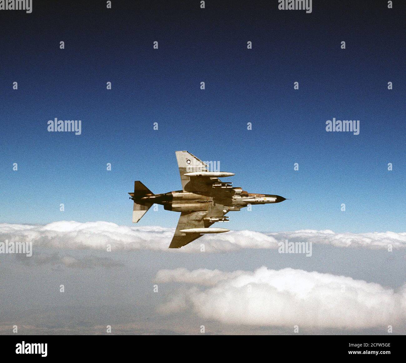 1977 - An underside view of an F-4 Phantom II aircraft banking sharply ...