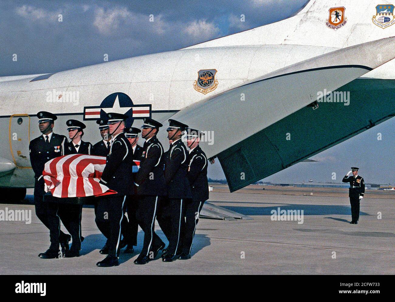 Honor Guard members carry the casket from a C-141 on arrival ca. 1978 ...