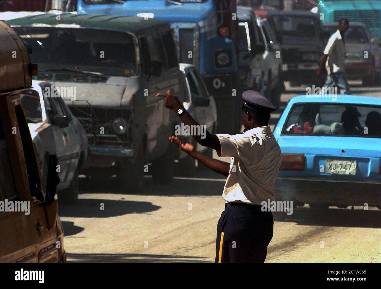 A Haitian National Policeman (HNP) directs traffic along the busy ...