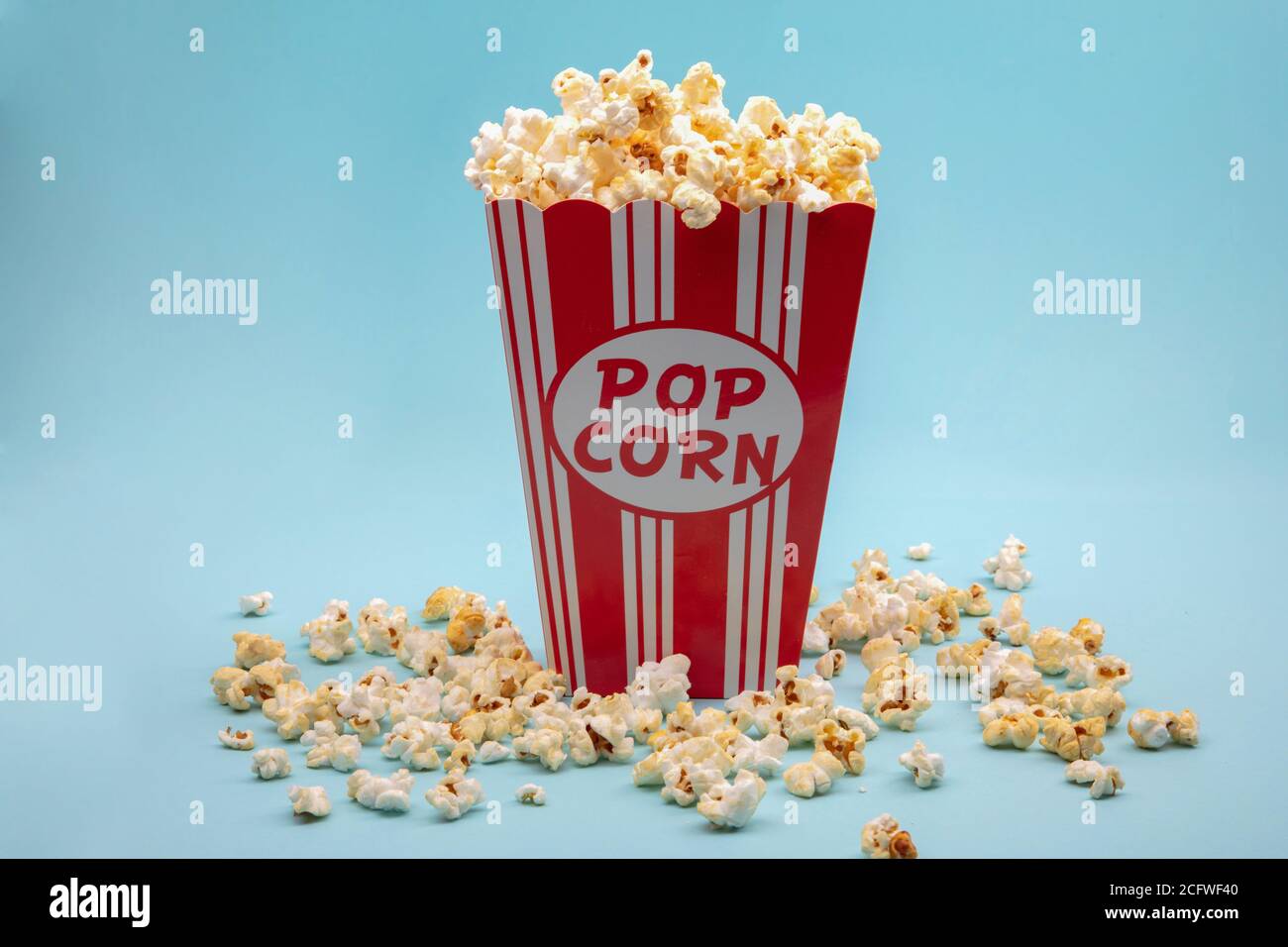 Large paper cup filled with salted Pocorn on bright blue Background ...