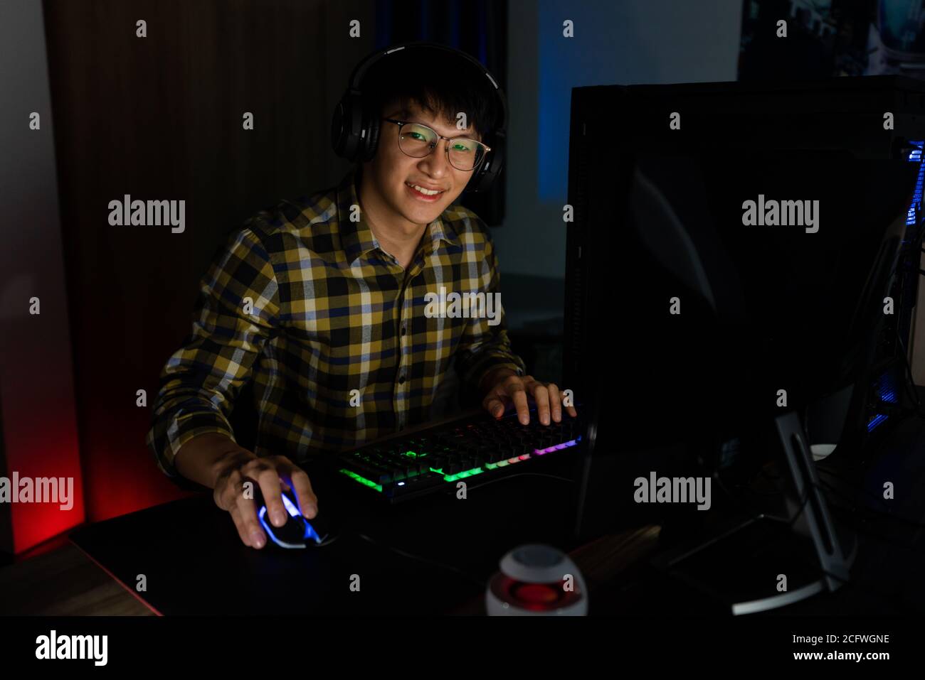 Handsome excited asian gamer guy in headphones enjoy and rejoicing ...