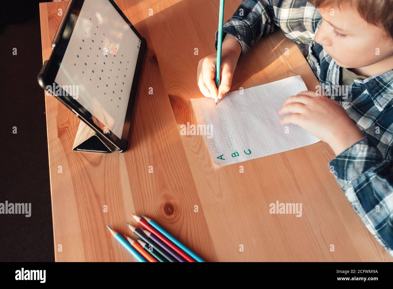 Modern child uses app on tablet to study and draw at home, distance ...