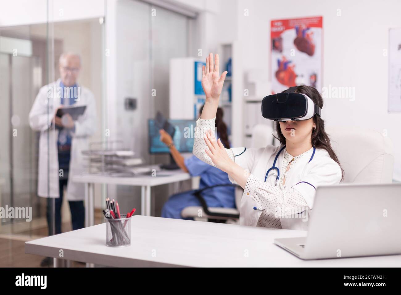 Doctor wearing high tech virtual reality goggles in hospital office and ...