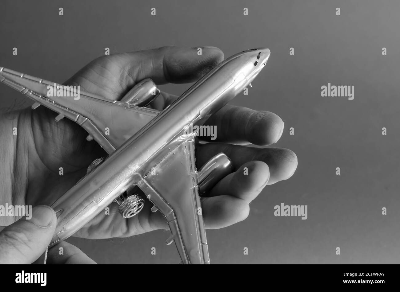 Model of a passenger plane in a man's hand. The hand holds the silver ...