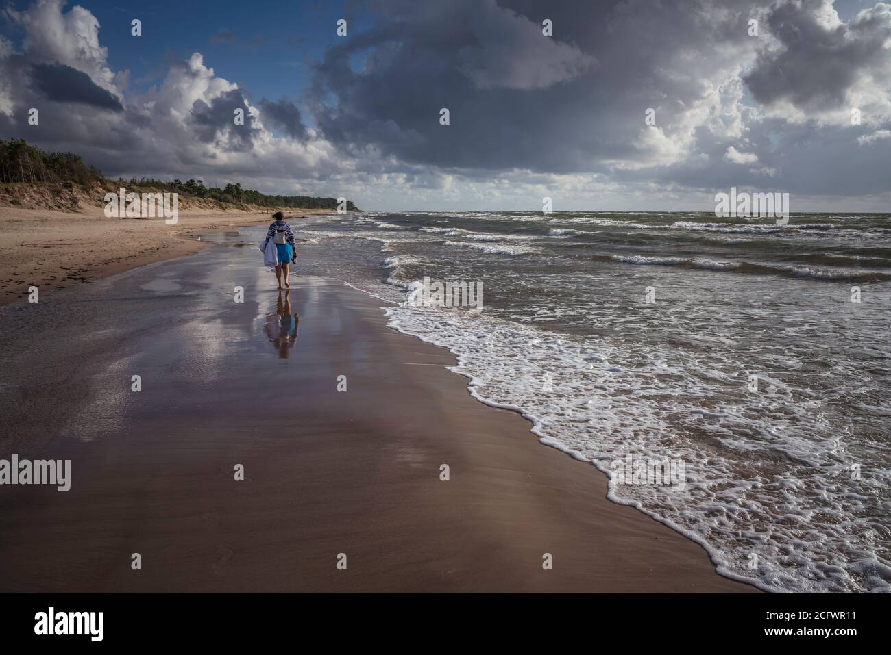 Baltic coast with passing people against the background of rain clouds ...