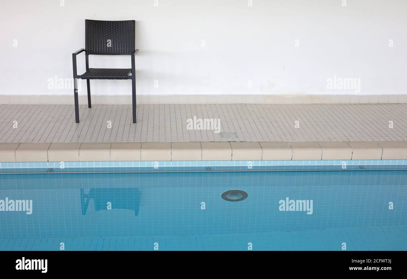 Chair in swimming pool, empty pool from the 90s Stock Photo - Alamy