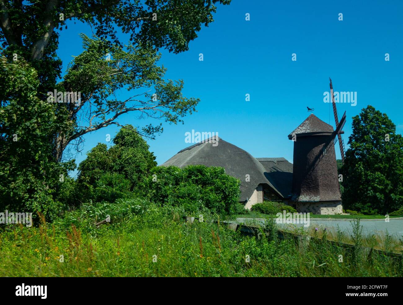 classic old wooden windmill with house nad trees Stock Photo - Alamy
