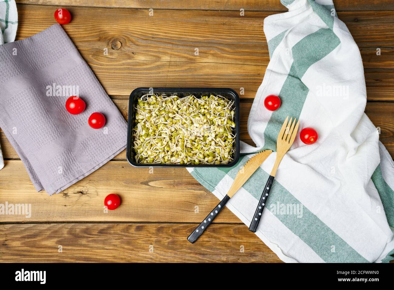 Photo of useful sprouts of mash in containers on a wooden background ...