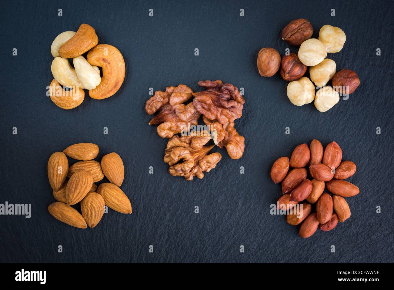 Mix nuts on a black slate background top view. Concept healthy snack ...