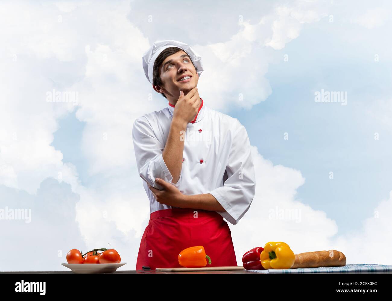 Portrait of a smiling male cook with arms crossed standing in the ...