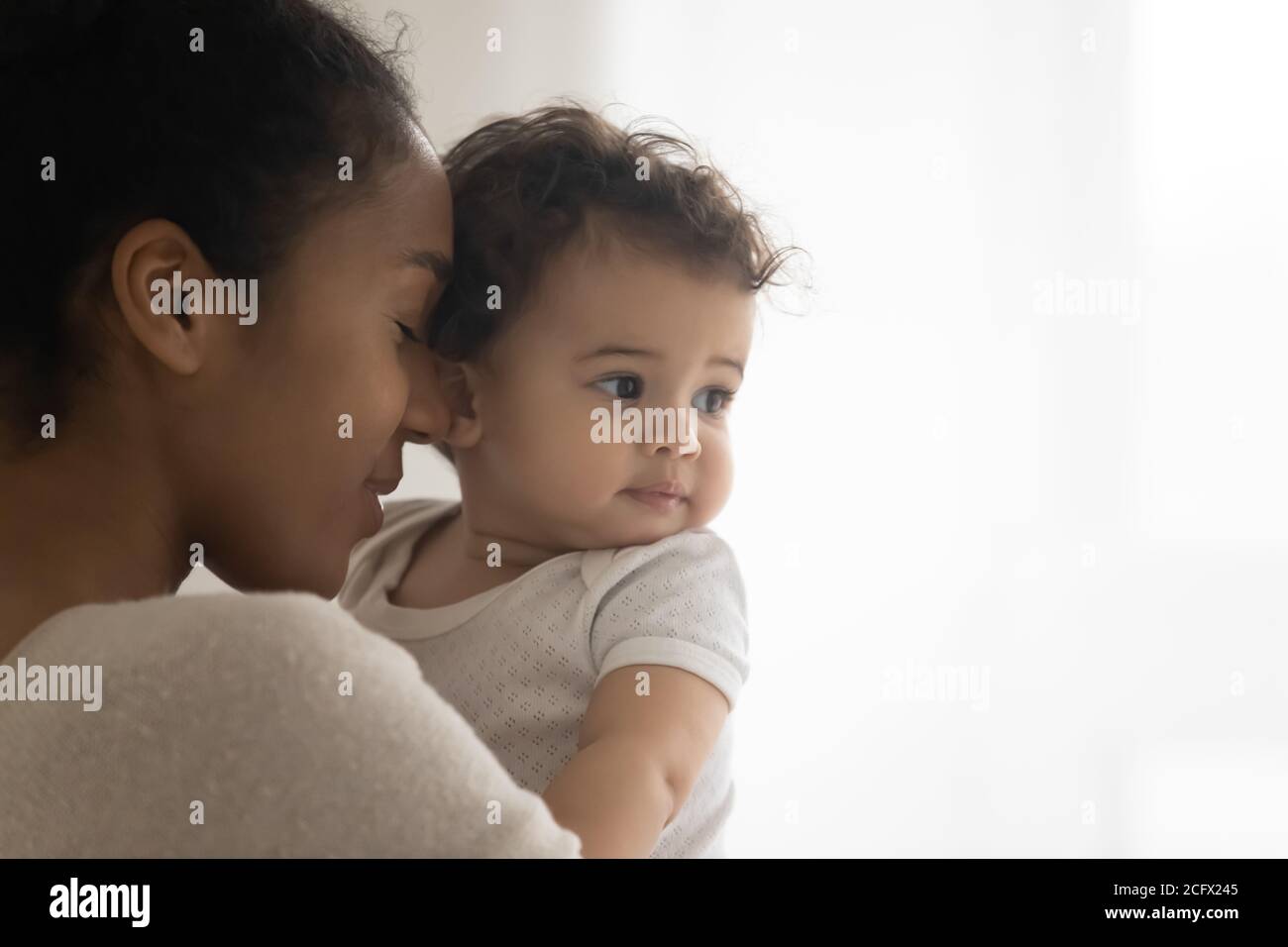 Loving young african ethnicity woman embracing cute sweet infant child ...