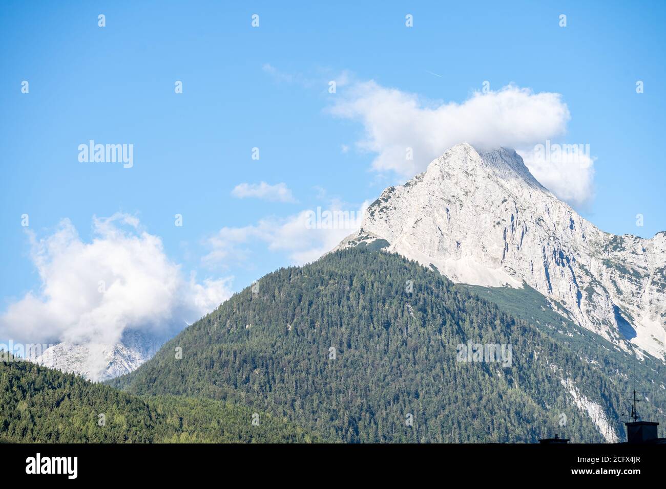 peaks of the wetterstein mountains in the clouds in the early morning ...