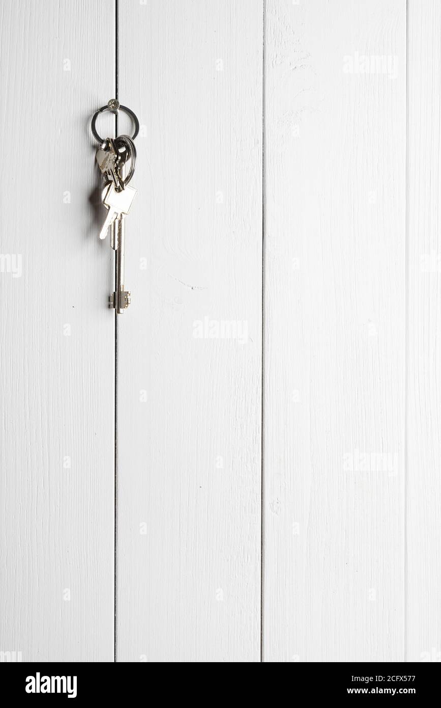 a bunch of keys hanging on a white wooden wall Stock Photo - Alamy