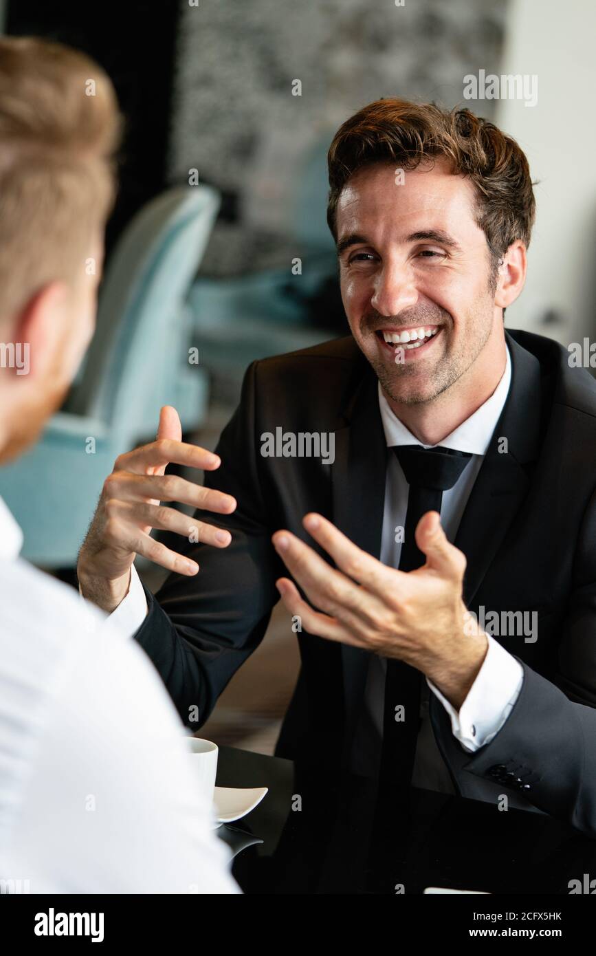Colleagues and friends. Two cheerful businessmen drinking coffee and ...