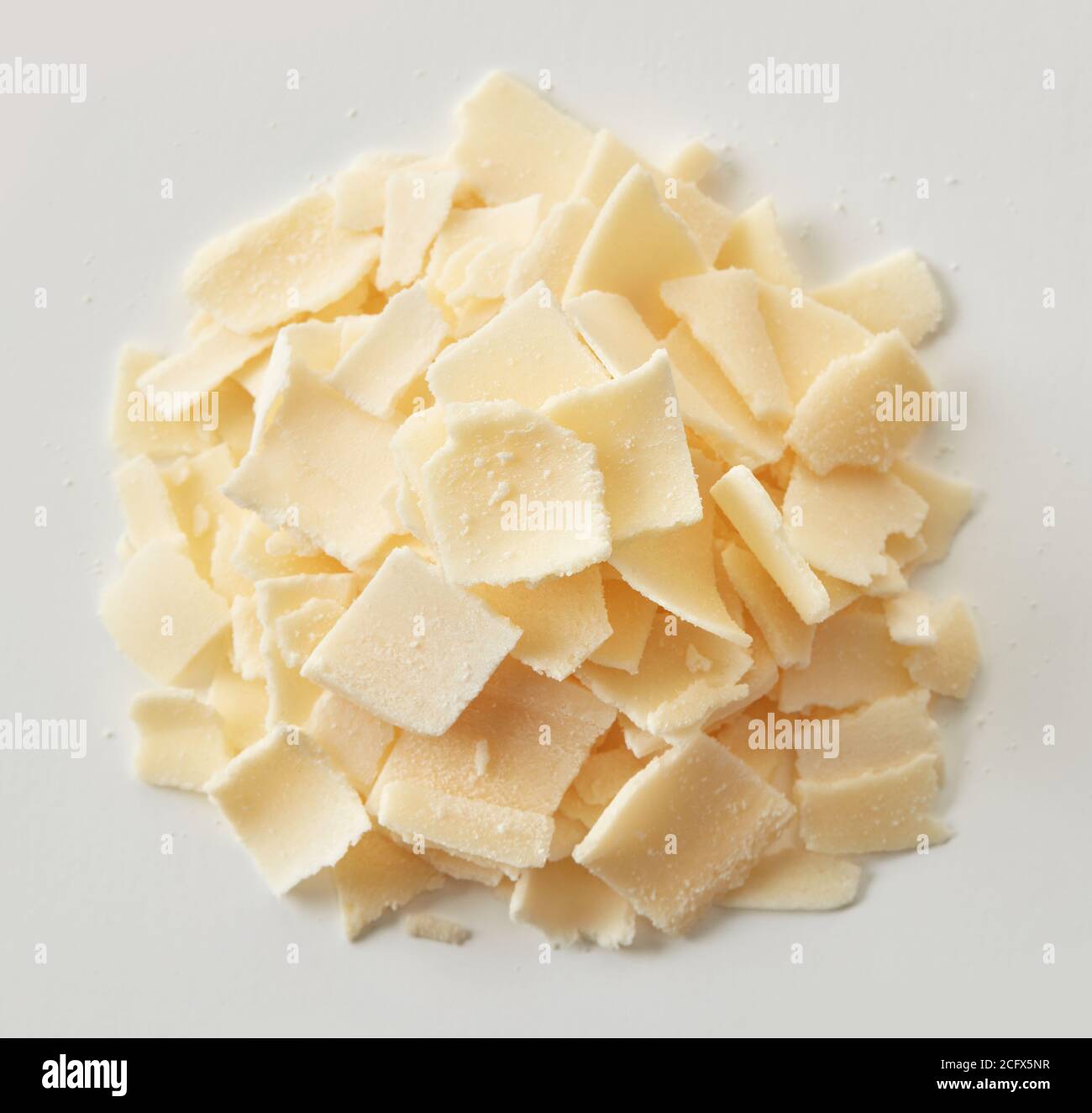 A stack of Parmesan flakes on white Stock Photo - Alamy