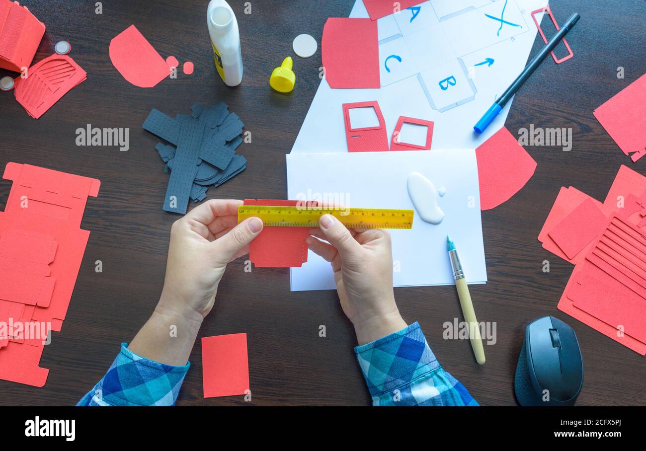 a designer working with paper modeling craft template Stock Photo - Alamy