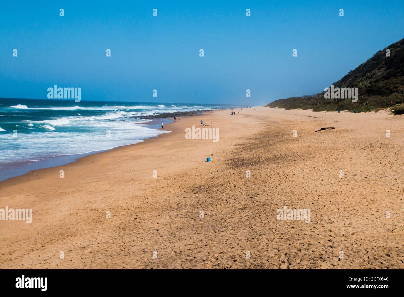 Expansive beach sand with deep blue ocean and clear sky Stock Photo - Alamy