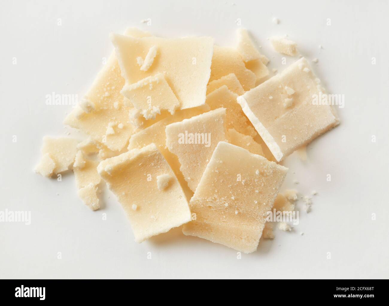 A stack of Parmesan flakes on white Stock Photo - Alamy