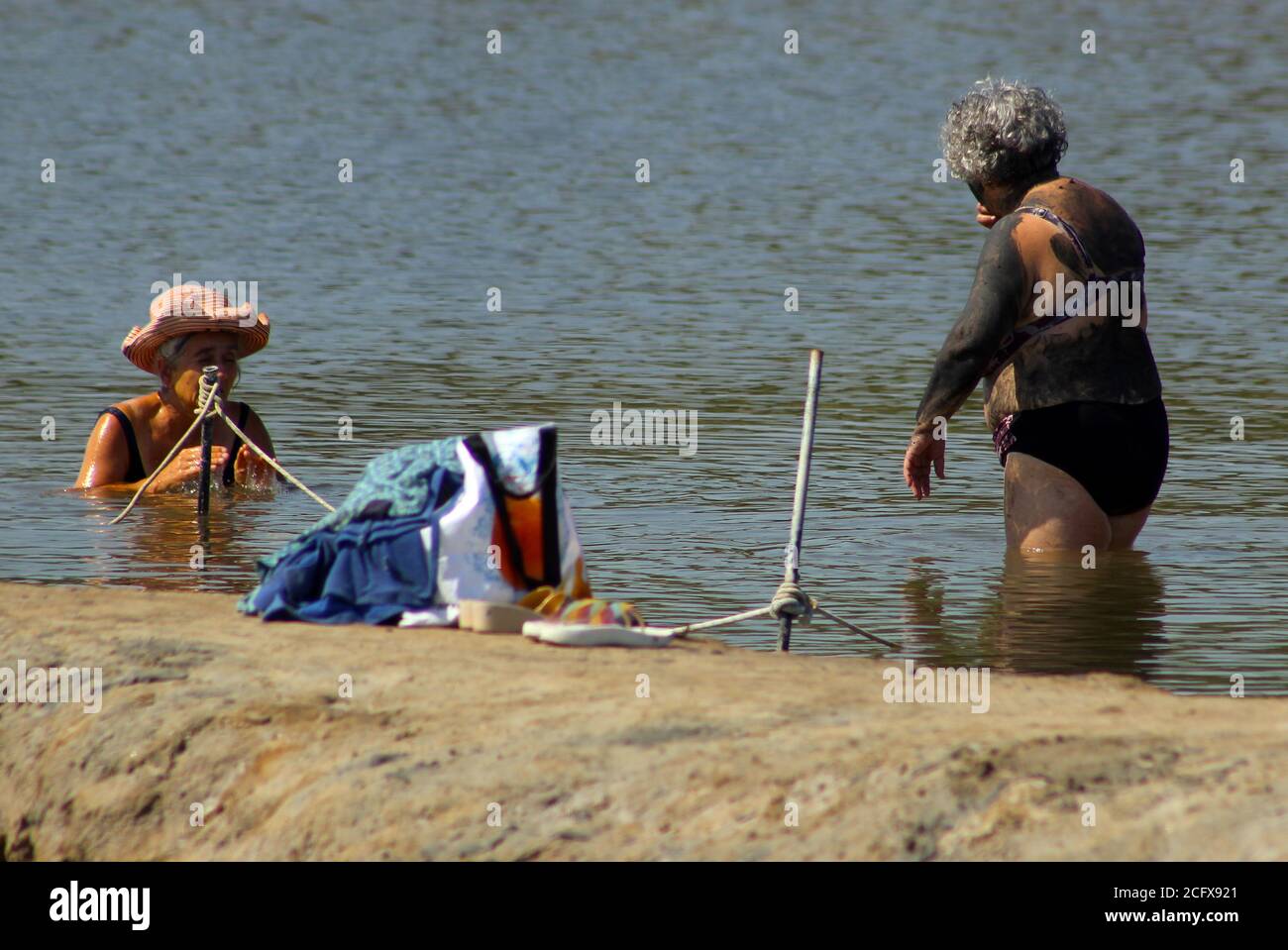 Visitors enjoy the mud-bathing process to help people who suffer from ...