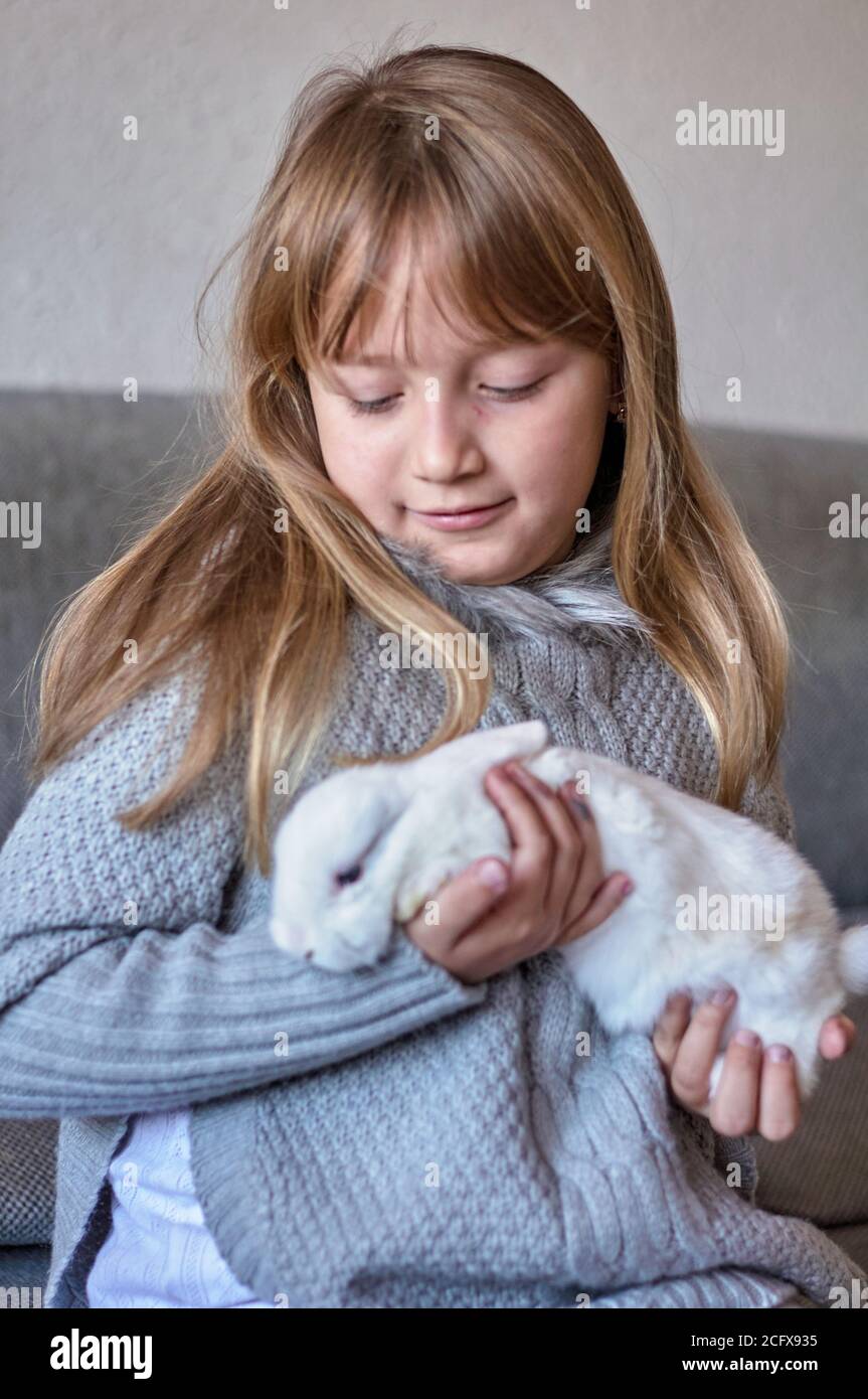 blonde girl with a white rabbit in her arms Stock Photo - Alamy