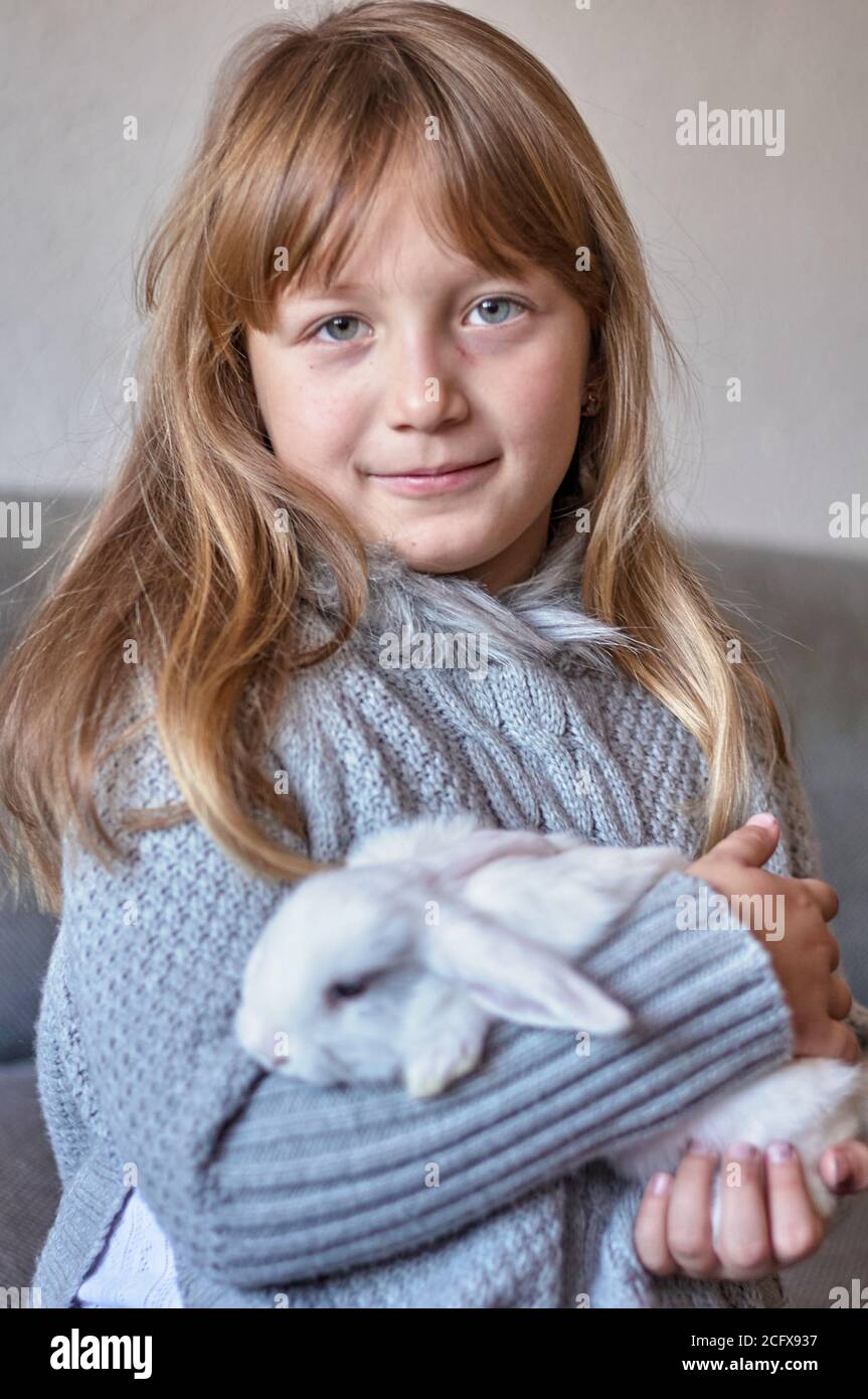 blonde girl with a white rabbit in her arms Stock Photo - Alamy