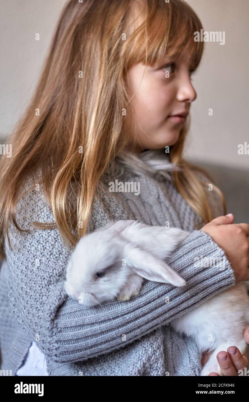 blonde girl with a white rabbit in her arms Stock Photo - Alamy