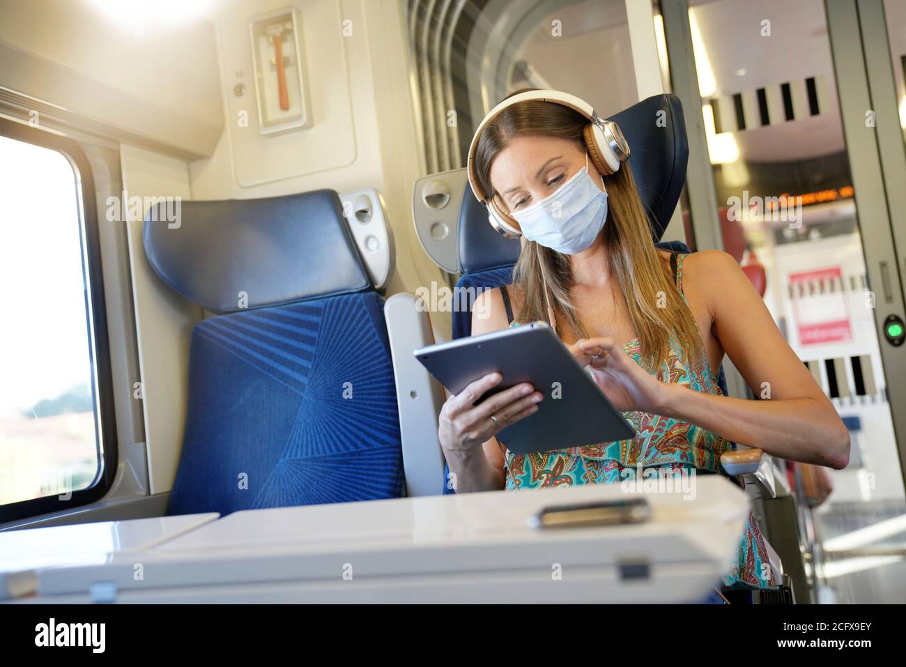 Young woman travelling by train, wearing face mask Stock Photo - Alamy