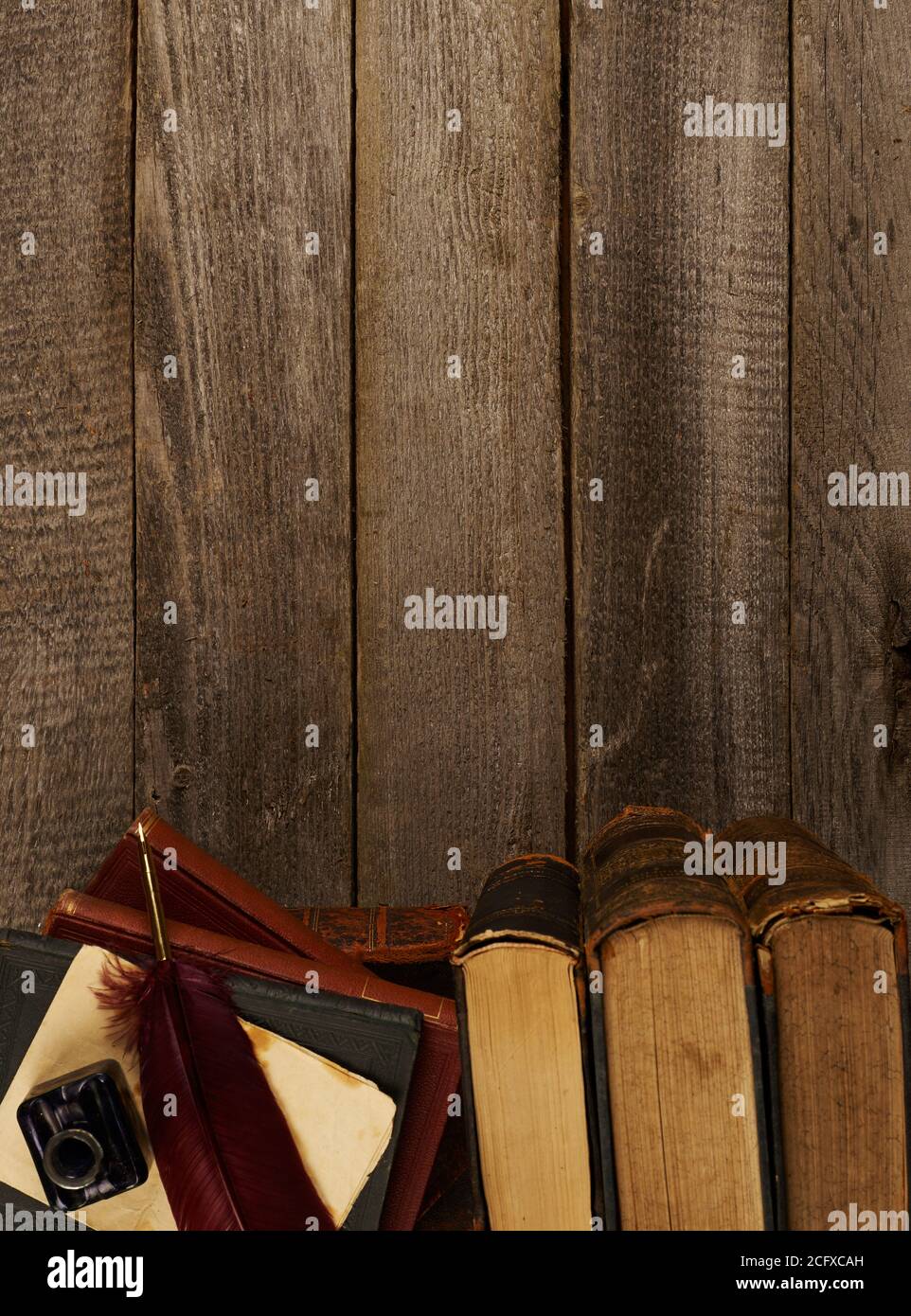 Antique books, quill pen and ink pot on table with copy space, view ...