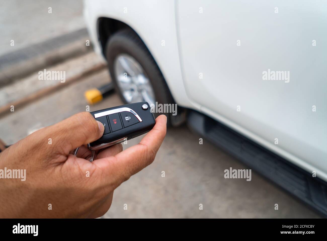 Hand pressing the button on the remote to lock or unlock the car with ...