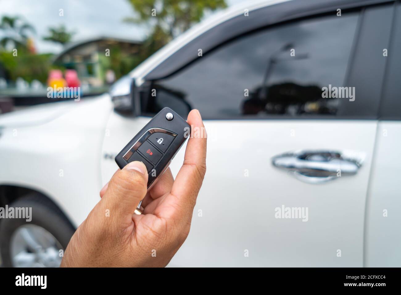 Hand pressing the button on the remote to lock or unlock the car with ...