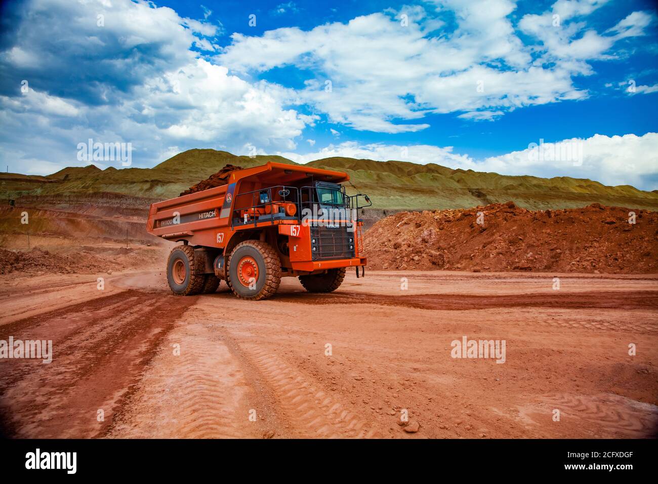 Orange Hitachi quarry dump-truck with bauxite. Aluminium ore mining and ...