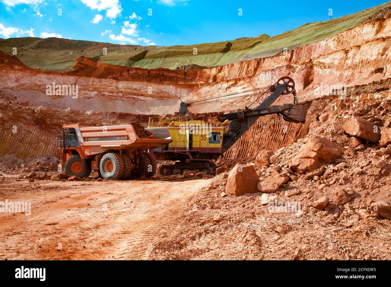 Excavator loads ore to Hitachi quarry dump truck. Aluminium ore mining ...