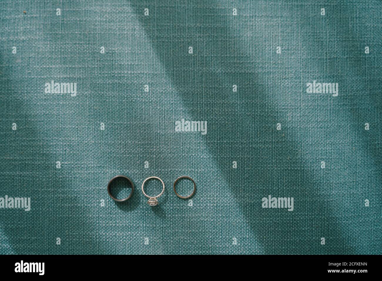 Precious wedding rings and an engagement ring for the bride on a dense ...