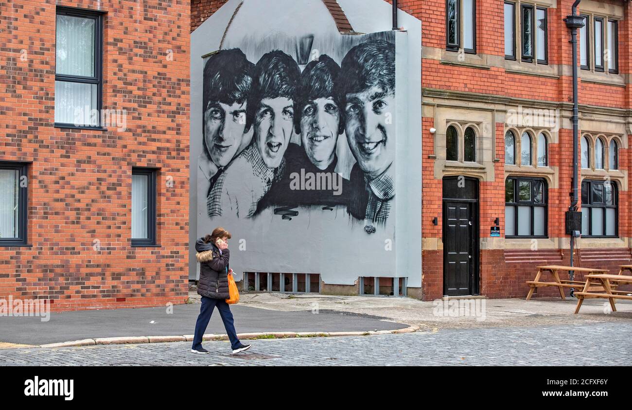 A woman walks past a new Beatles mural on the gable end of The Pheonix ...