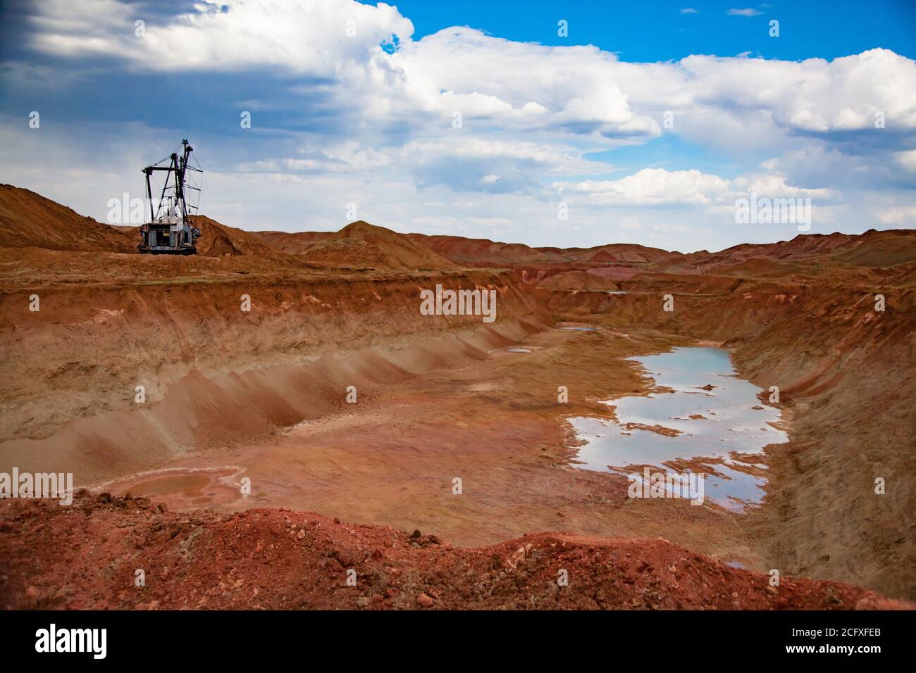 Walking dragline excavator in bauxite clay quarry. Heaps of minerals ...