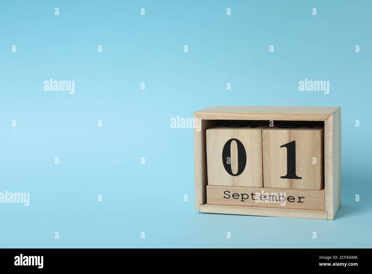 Wooden calendar with date September 1 on blue background, space for ...