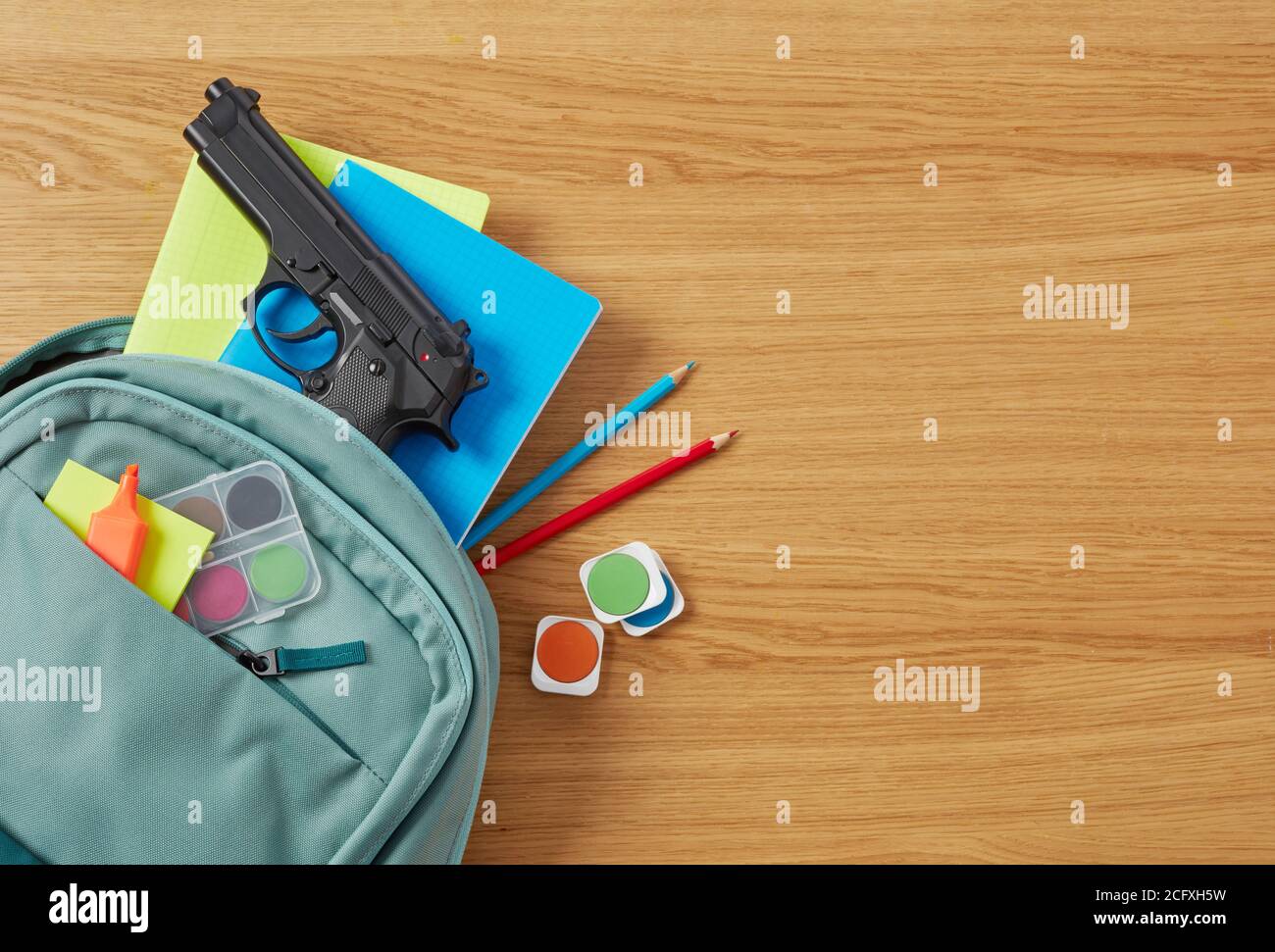 Backpack, school supplies and gun on desk Stock Photo - Alamy