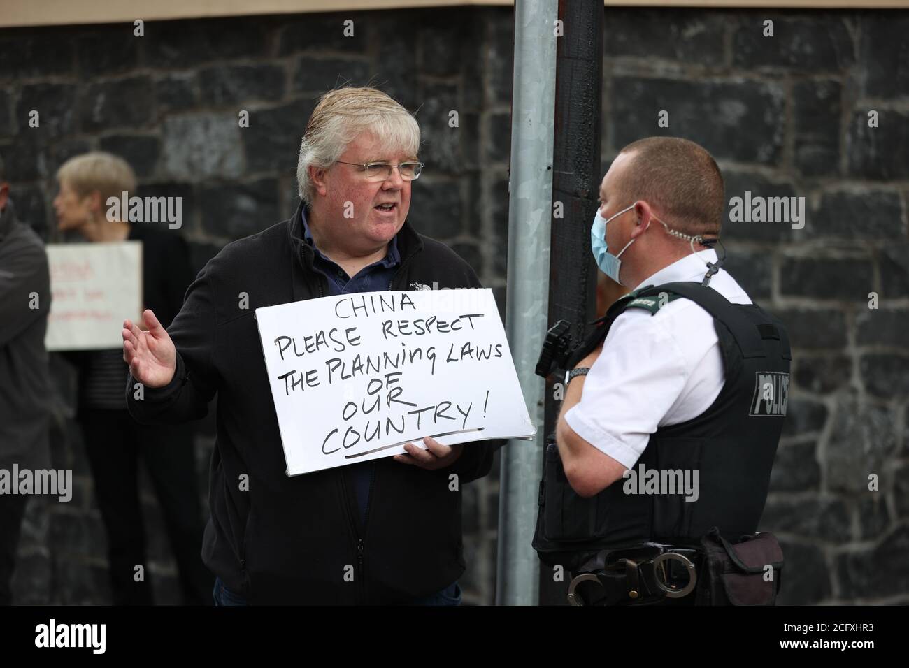 A resident speaks to an officer from the PSNI during a protest outside ...