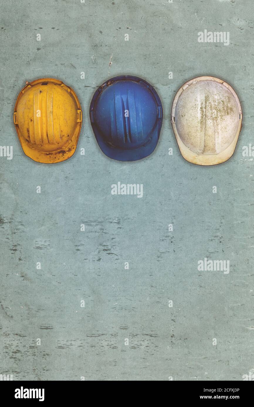 Three old and worn construction helmets hanging on a wall Stock Photo ...