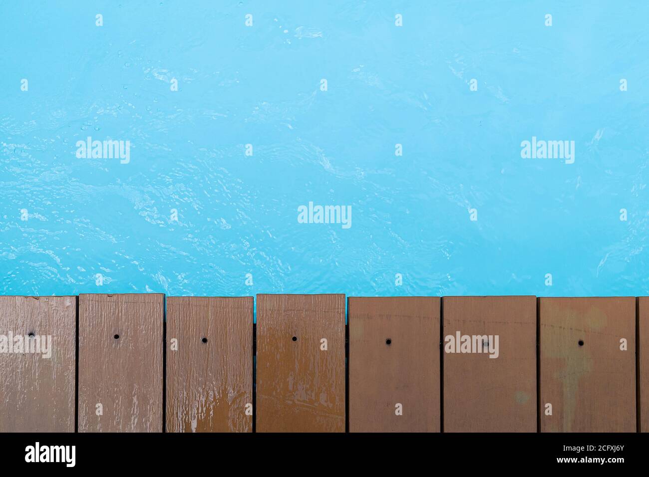 Close up. Swimming pool with teak wood flooring stripes summer vacation ...