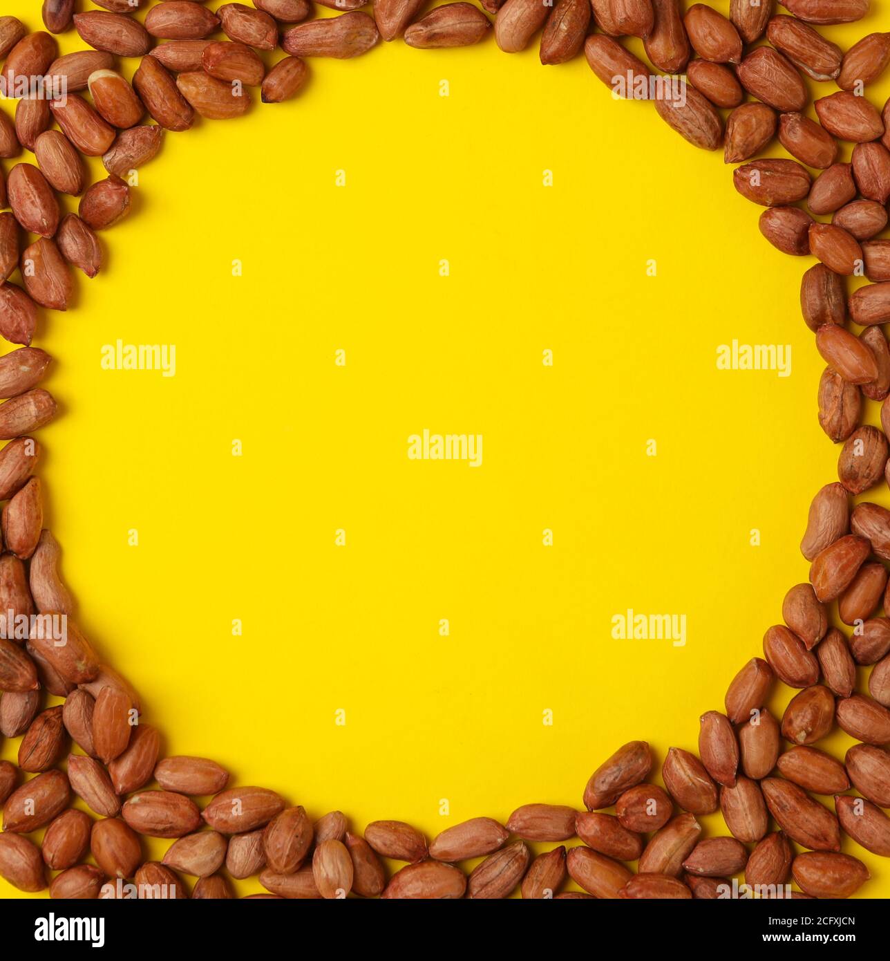 Circle made of peanut on yellow background, space for text Stock Photo ...