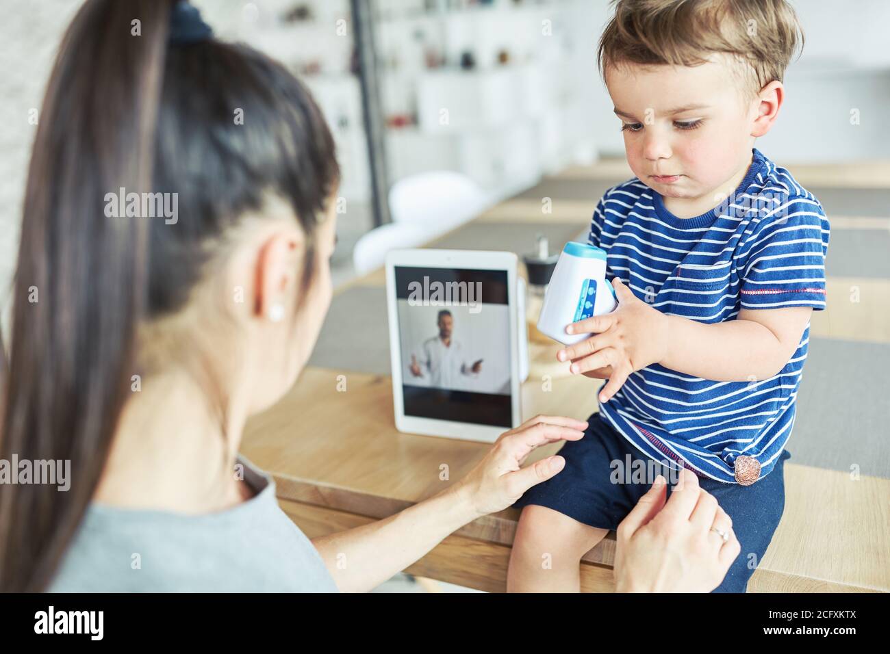 Mother and child in the online consultation with the pediatrician via ...