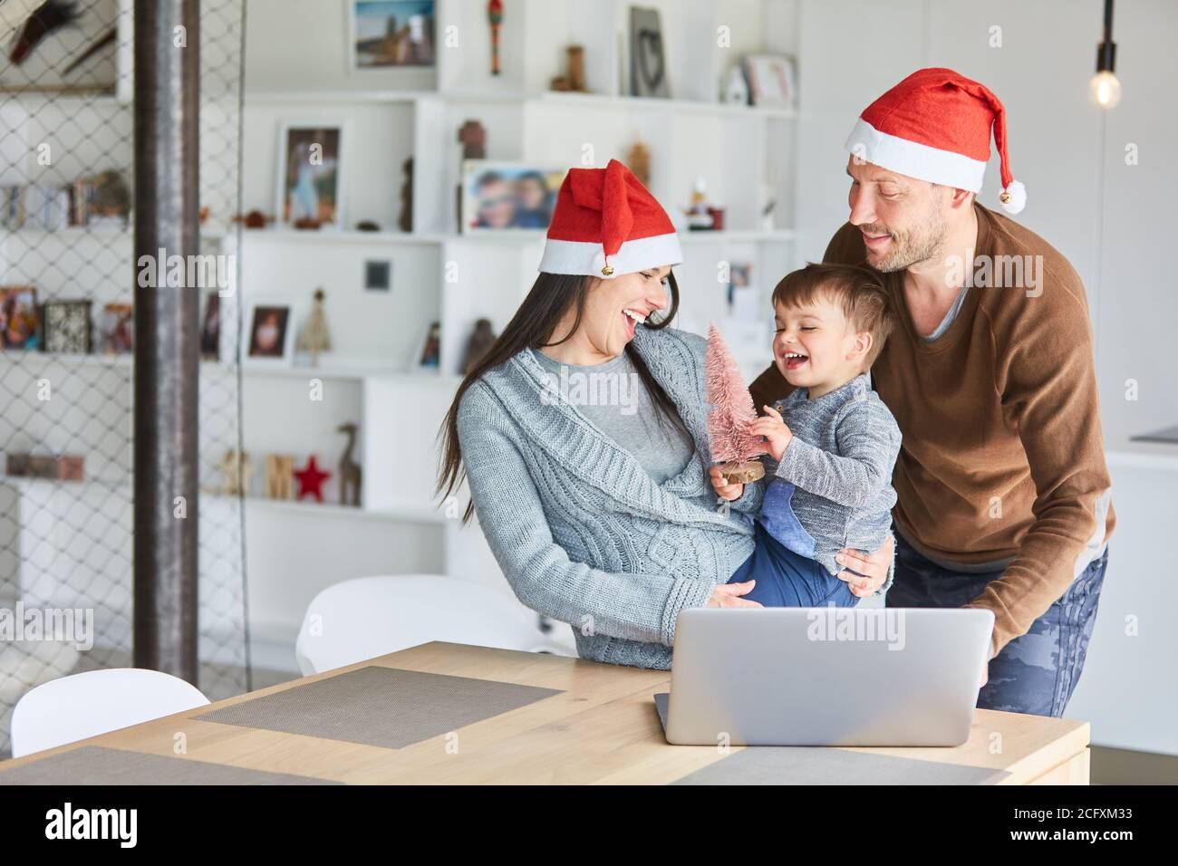 Family with toddler with a small fir tree celebrates Christmas in video ...