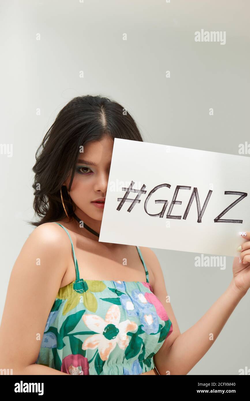 Young millennial teenage with a funny expression, holds a sign with the ...