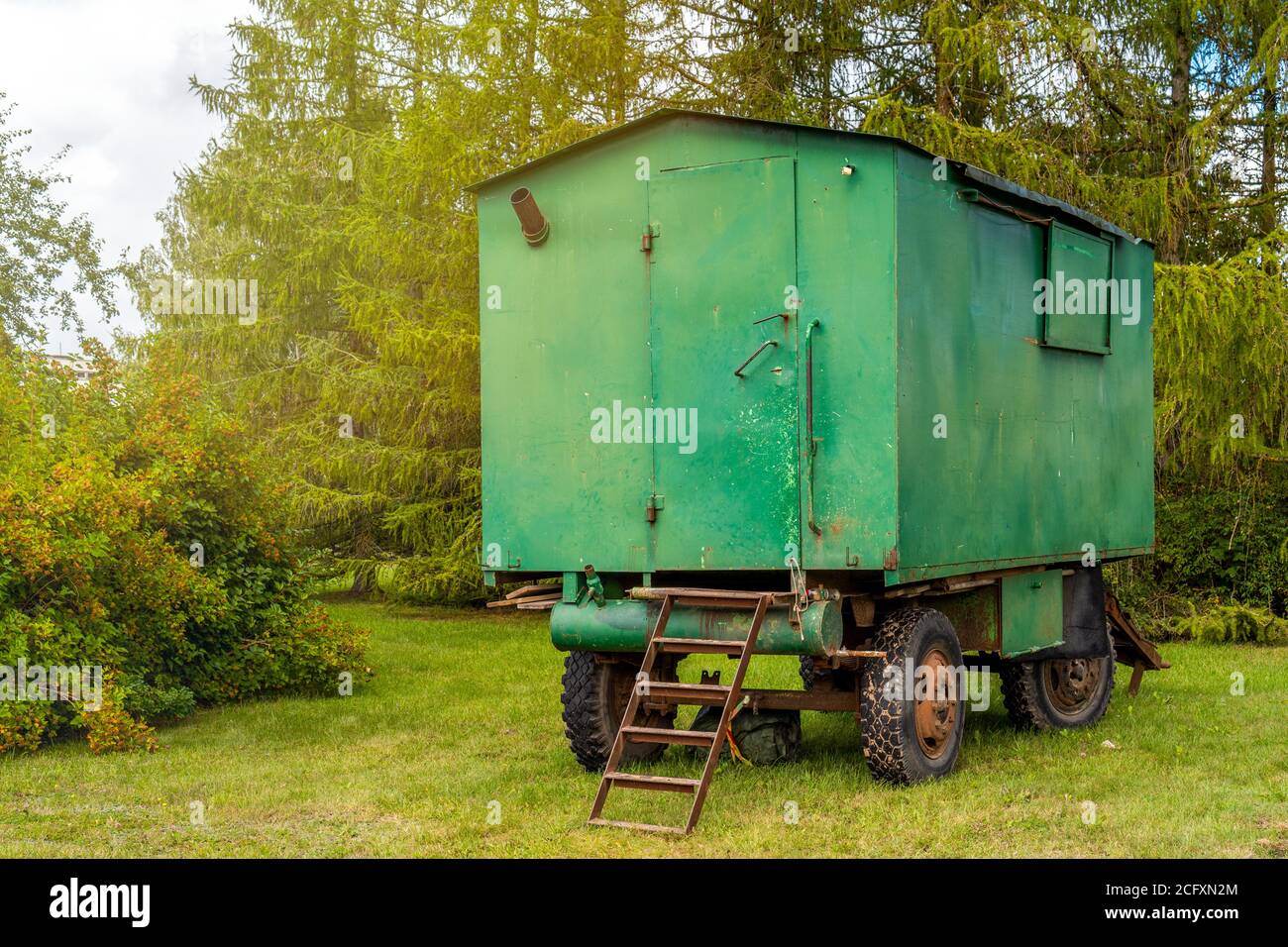 Old green rusty construction camper, trailer, van or wagon. Temporary ...