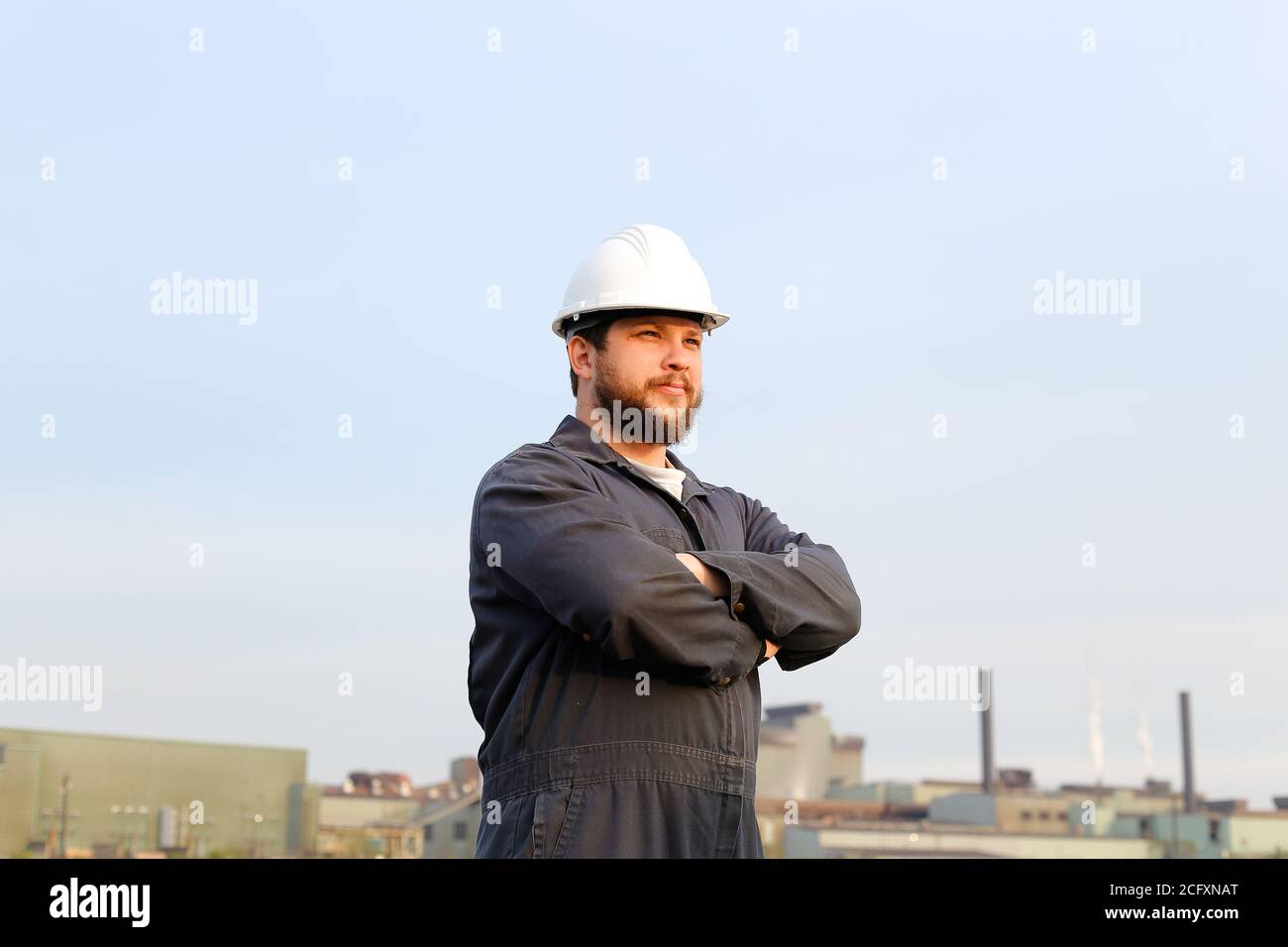 Portrait of european foreman in helmet standing in construction site ...
